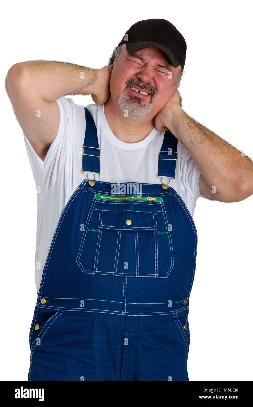 Worker in bib overalls with neck aches clutching his neck with his ...