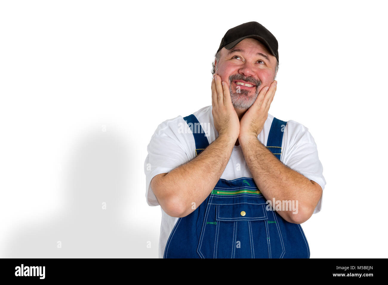 Thankful farmer or workman looking up smiling with his hands to his ...