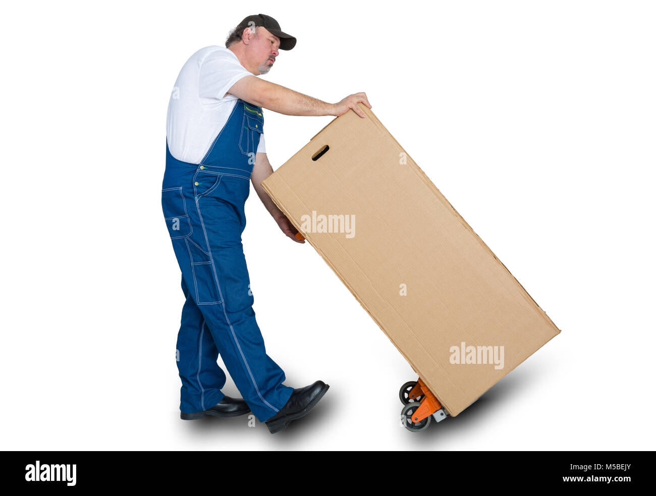 Deliverer transporting large cardboard box using trolley against white ...