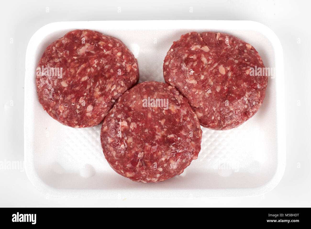 Tray with raw beef burgers isolated on white background Stock Photo - Alamy