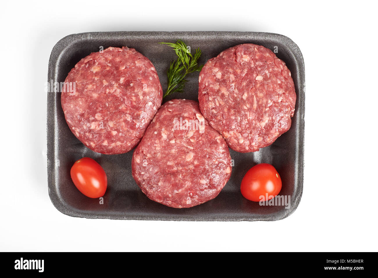 Tray with raw beef burgers or minced meat isolated on white background ...