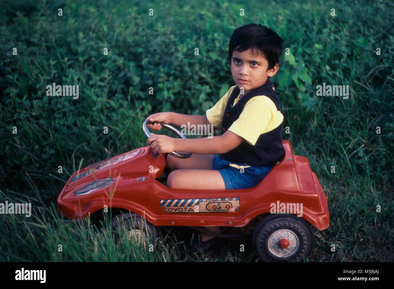 Boy driving a model car, India Stock Photo - Alamy