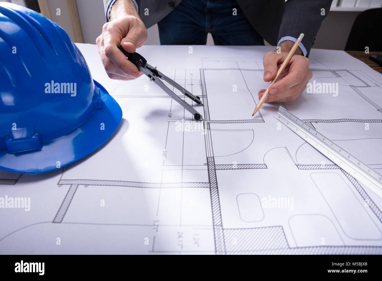 Close-up Of Architecture's Hand Working On Blueprint With Hardhat On ...