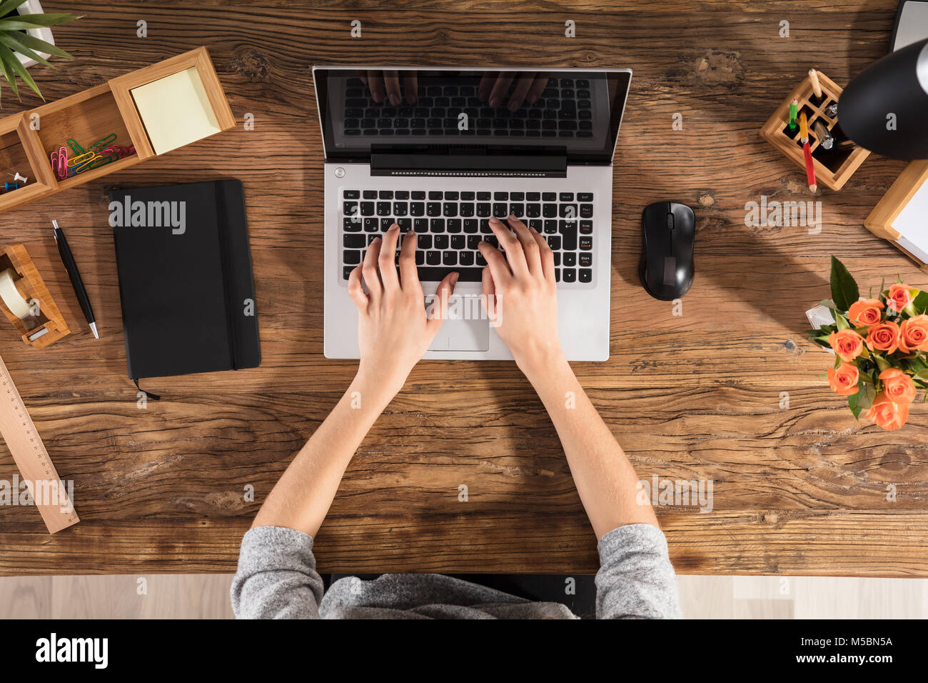 Close-up Of A Person Using Laptop Computer On Office Wooden Desk Stock ...