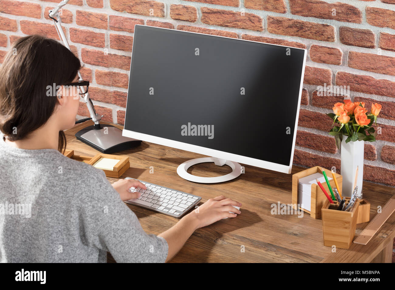 Rear View Of A Woman Using Computer Stock Photo - Alamy