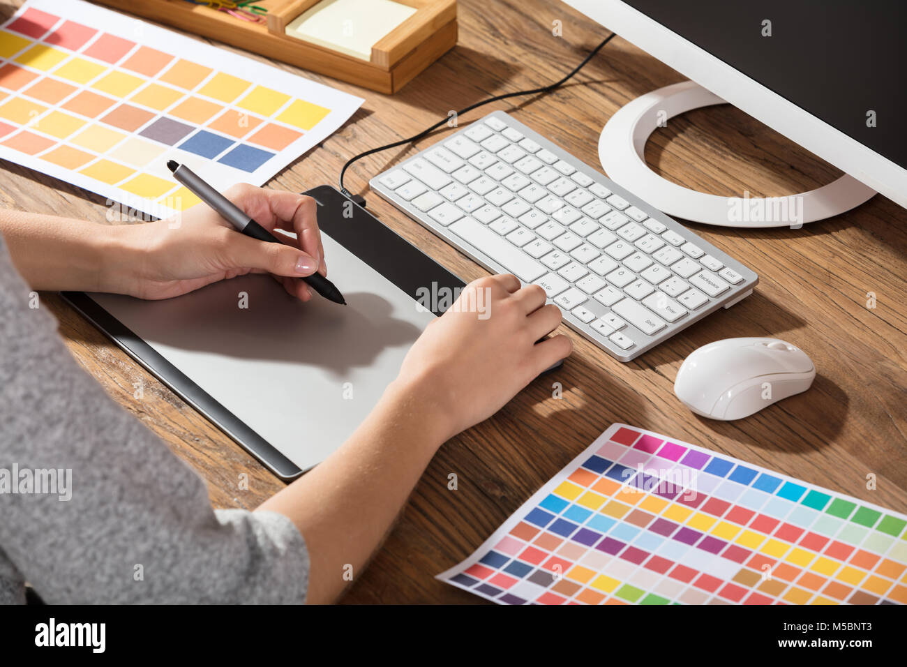 Graphic Designer Using Graphic Tablet With Color Samples On Desk Stock ...