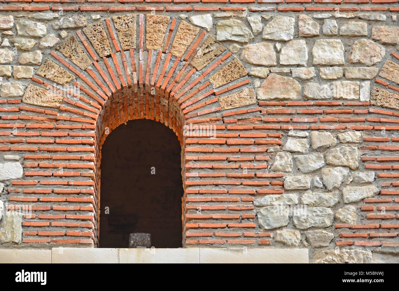 Ancient Roman Arch in a mixed stone and brick wall Stock Photo - Alamy