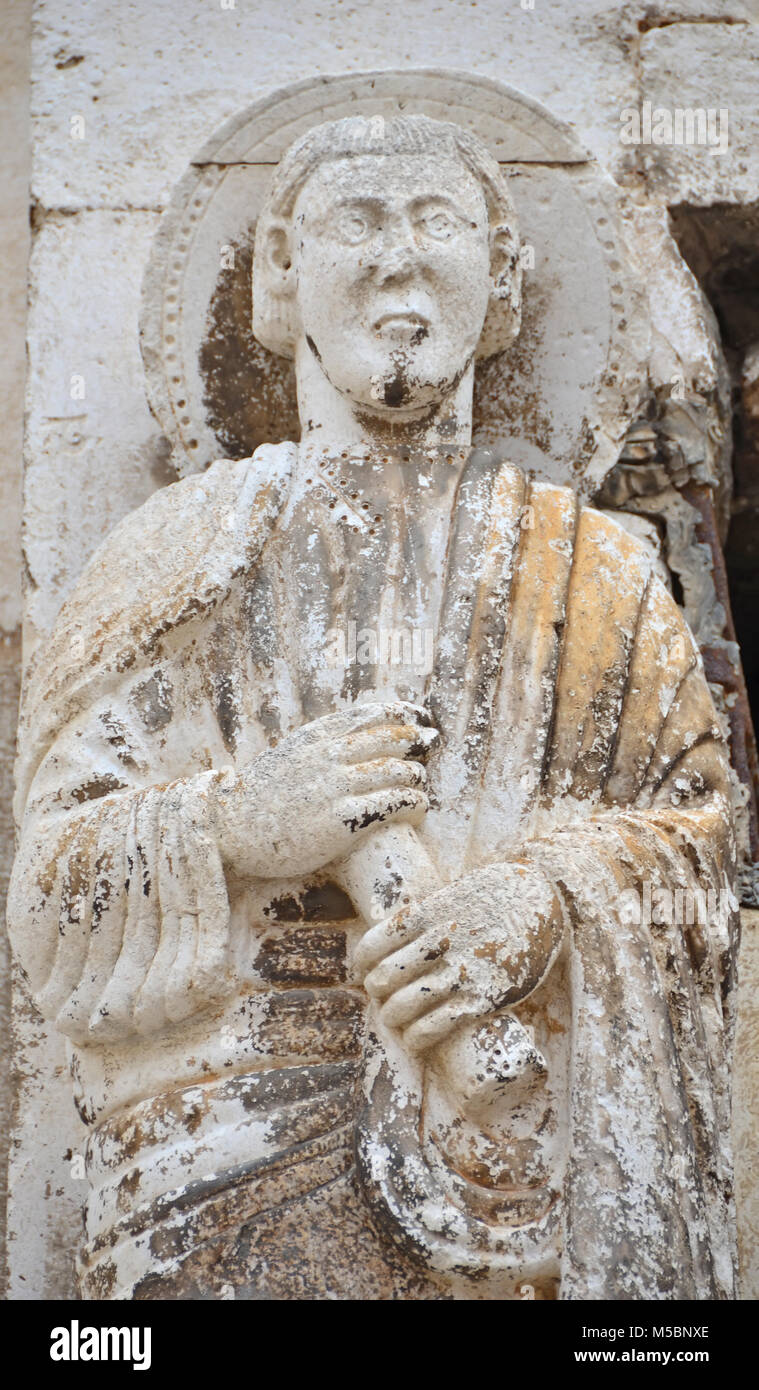 Medieval sculpture of the evangelist St Luke holding his scripture ...
