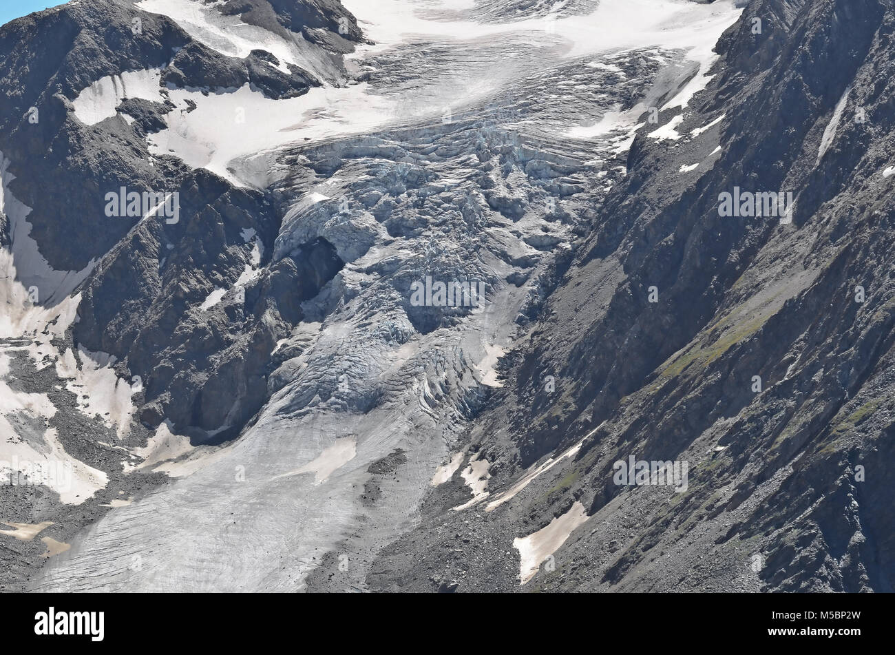 A glacier flowing down a steep uneven slope, creating an ice fall Stock ...