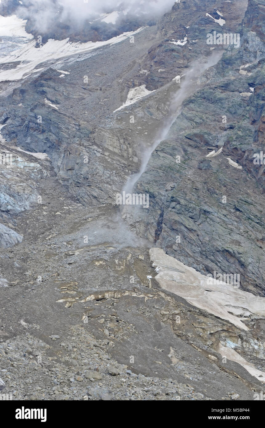 A rockfall in the mountains caused by melting ice. Falling rocks ...