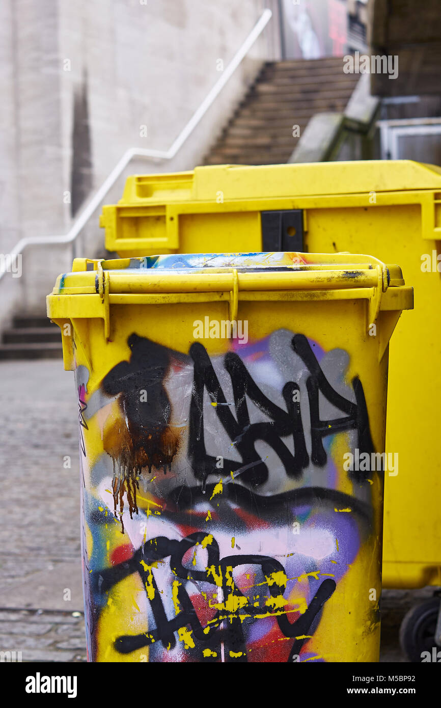 a pair of heavily tagged yellow plastic rubbish bins Stock Photo - Alamy