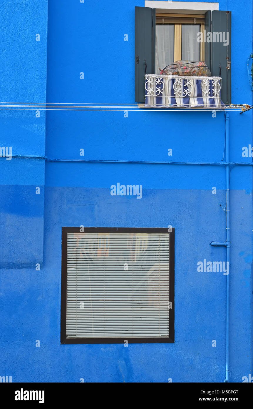 house with bright blue wall, and two windows Stock Photo - Alamy