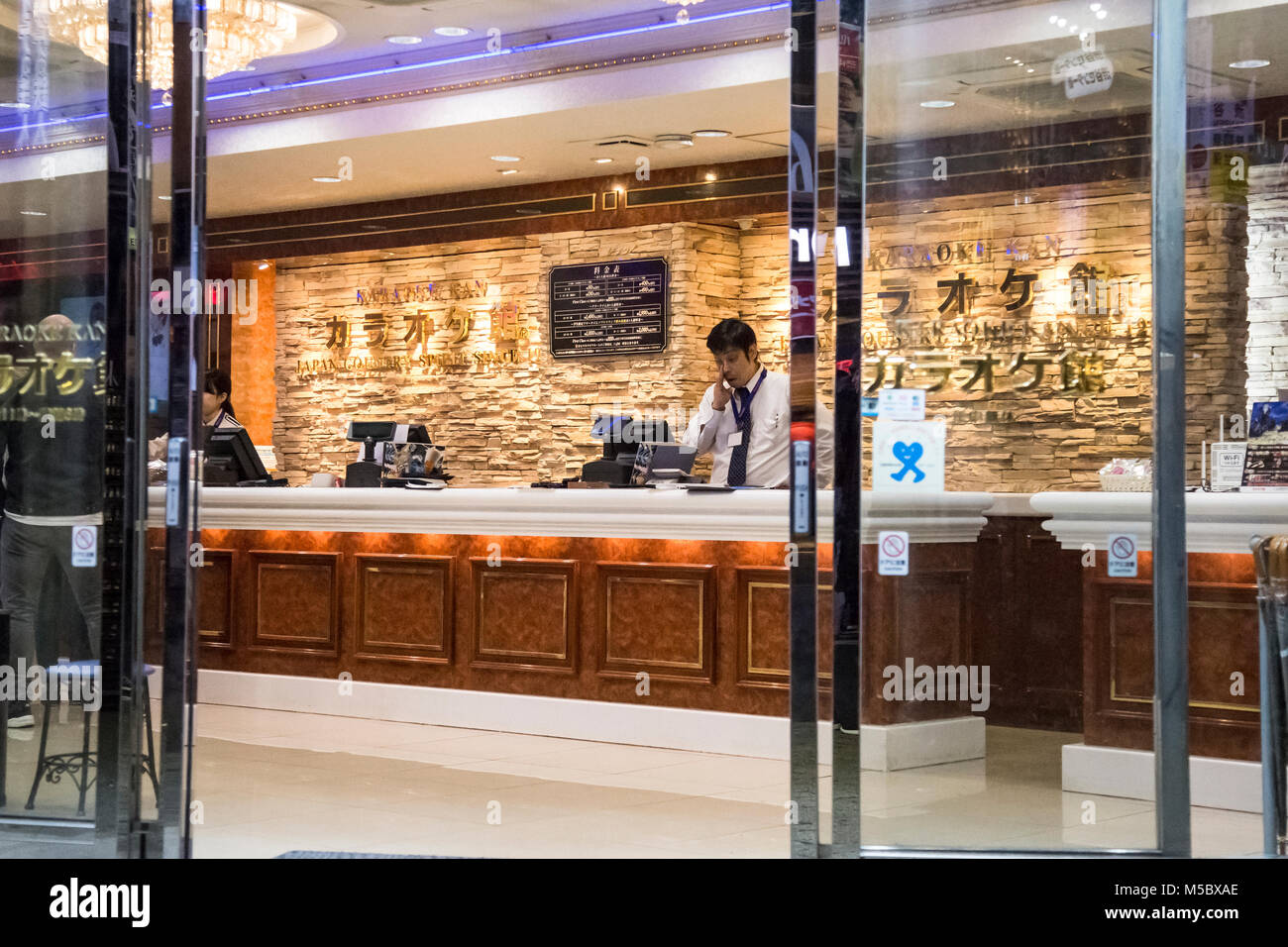 the receptionist at the front desk of a karaoke club Stock Photo - Alamy