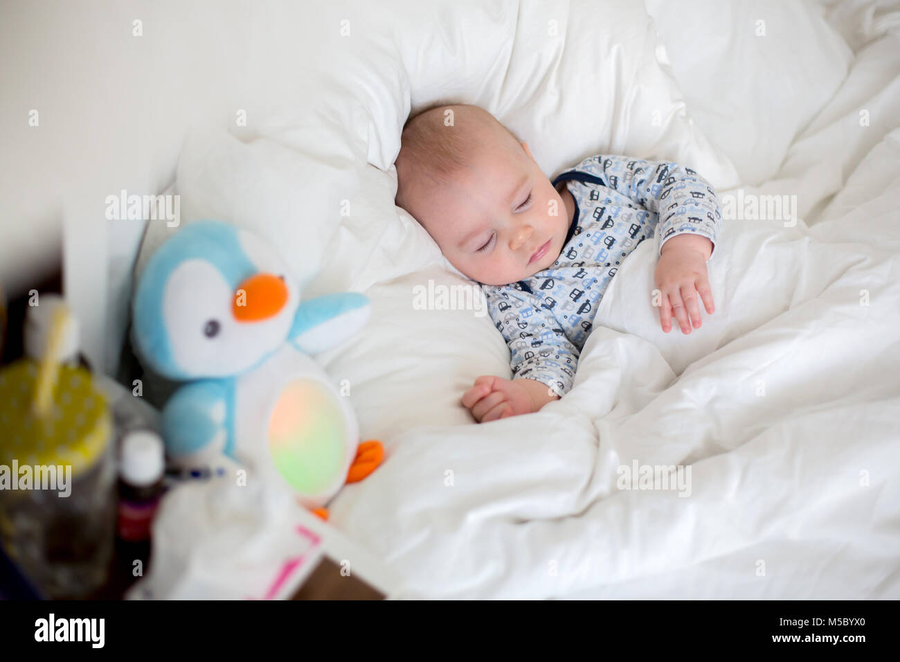 Sick chidl, bab boy lying in bed with a fever, resting at home Stock ...