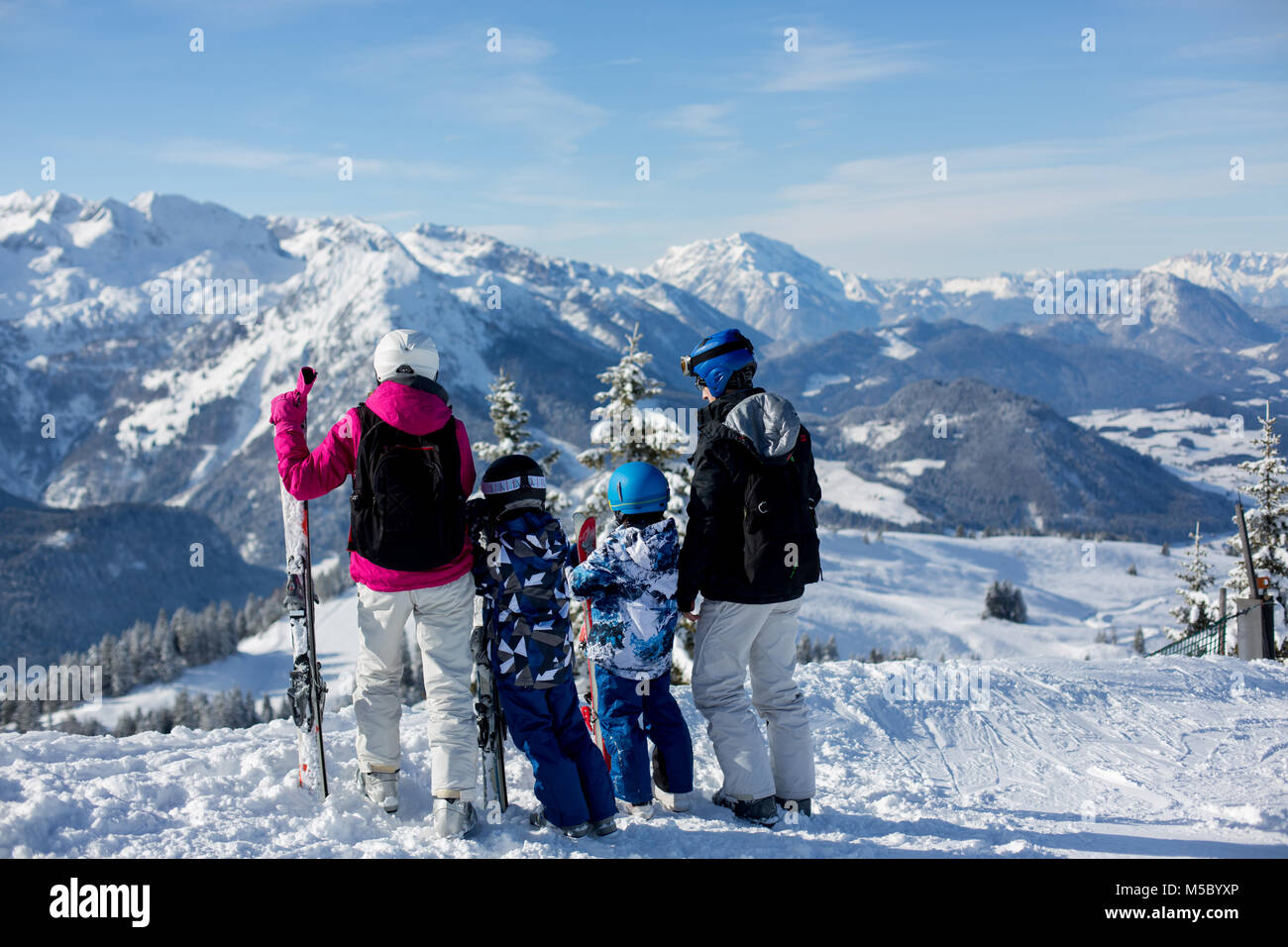 Happy family, mother, father and two children, skiing in Austrian Alps ...