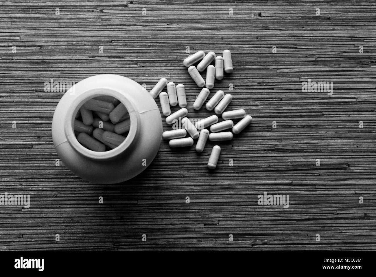 The medicines scattered from a bottle as capsules Stock Photo - Alamy