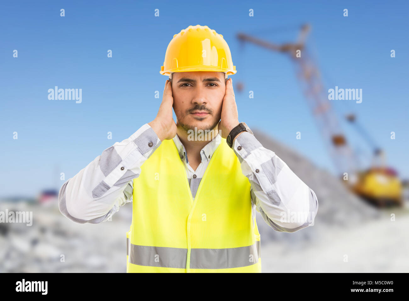 Construction worker or engineer covering his ears as silence after ...