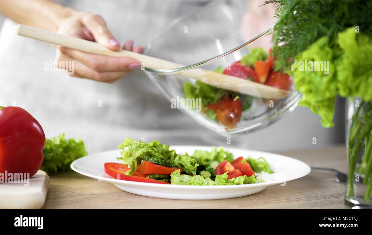 Lady putting fresh salad on her plate, going to have lunch, healthy ...