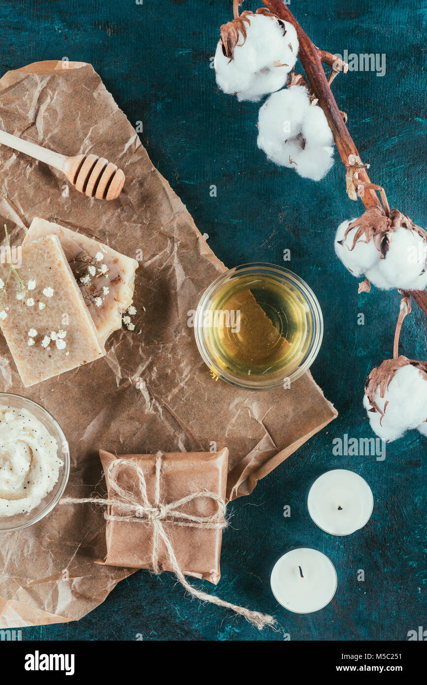flat lay with natural soap, oil, salt scrub and cotton flower on ...