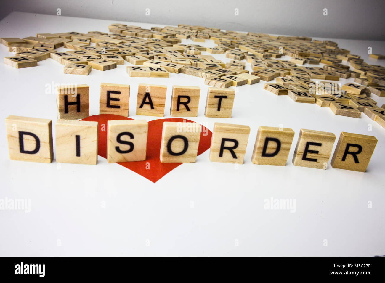 Wooden letters spelling the phrase HEART DISORDER on white background ...