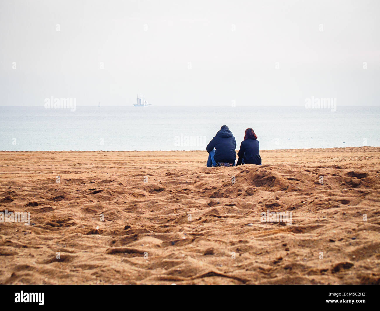Two people sitting on a beach hi-res stock photography and images - Alamy