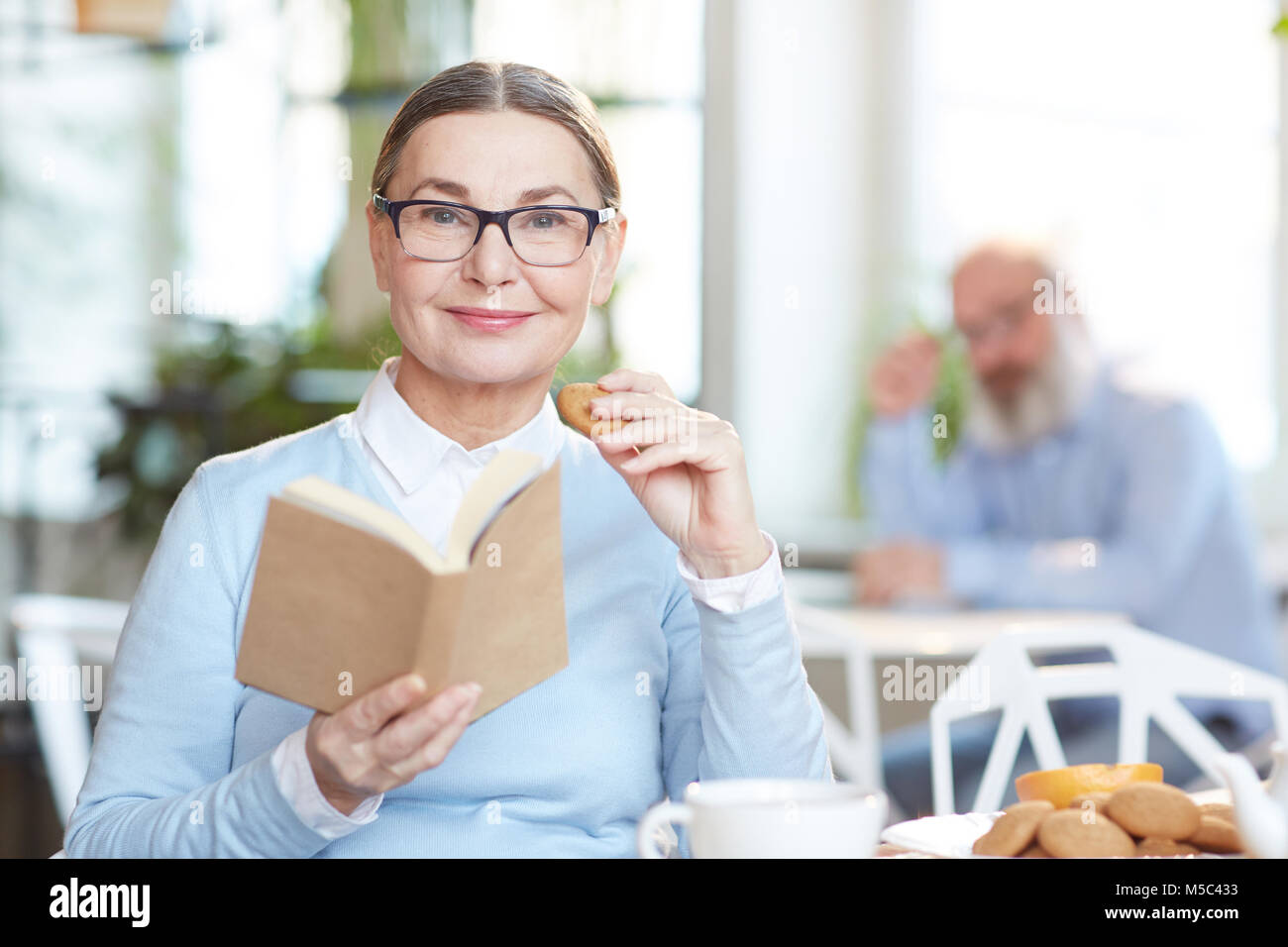 Reading in cafe Stock Photo - Alamy