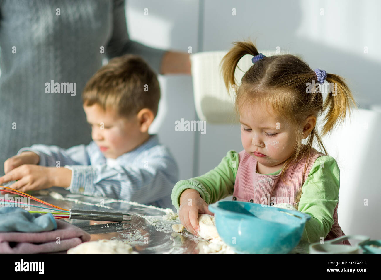 Two small children prepare something from the dough. A boy and a girl ...