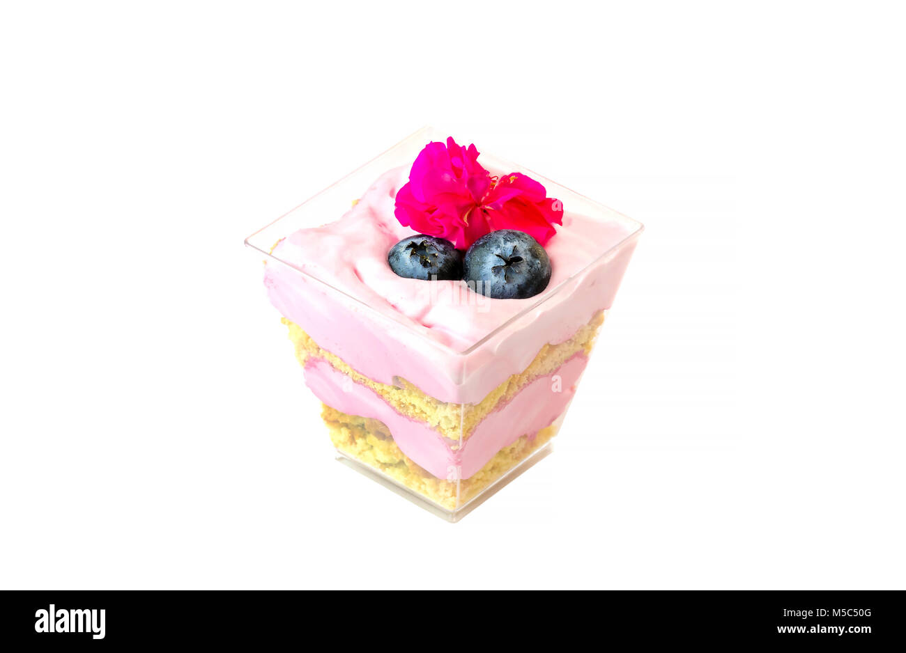 Creamy cream dessert in a plastic cup decorated with berries on a white ...