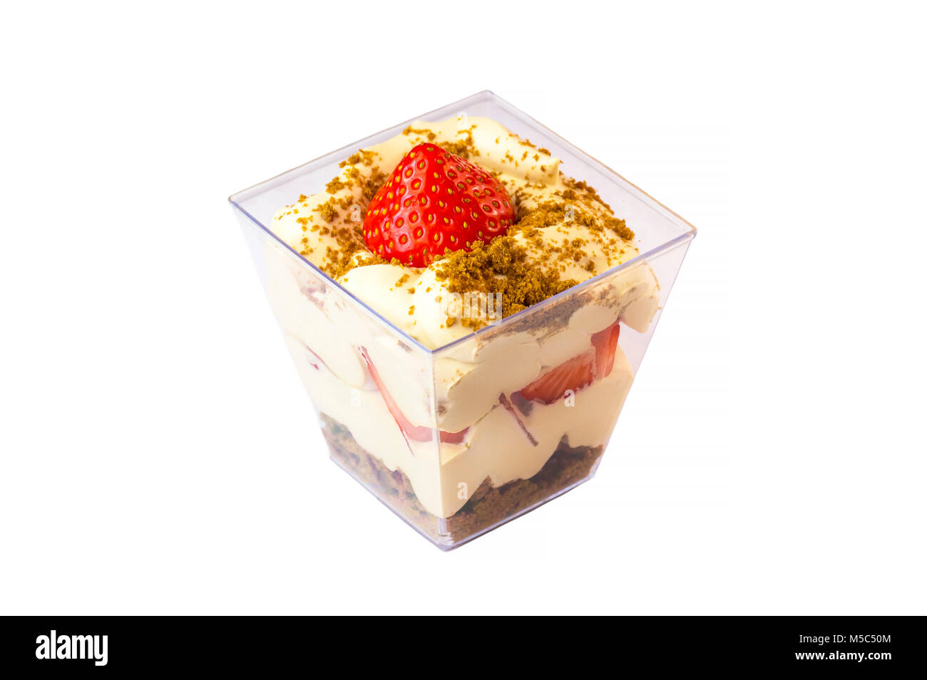 Creamy cream dessert in a plastic cup decorated with berries on a white ...