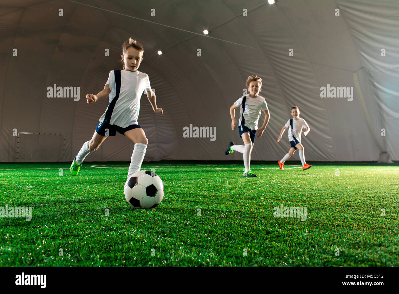 Boy running after soccer ball hi-res stock photography and images - Alamy