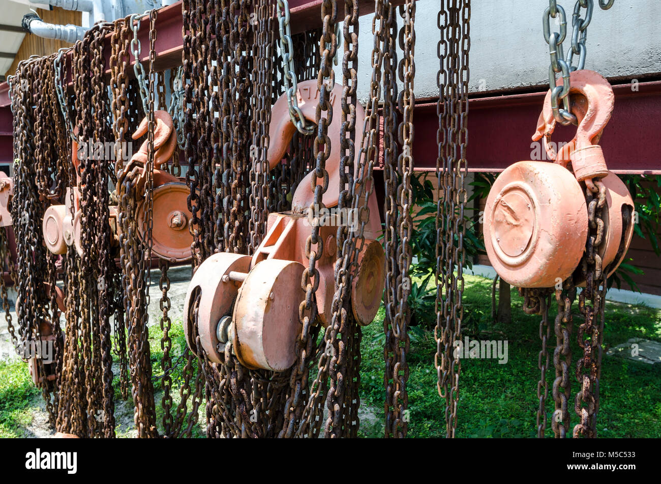 Old rusty metal hoist chain and pulley- Several old industrial chain ...