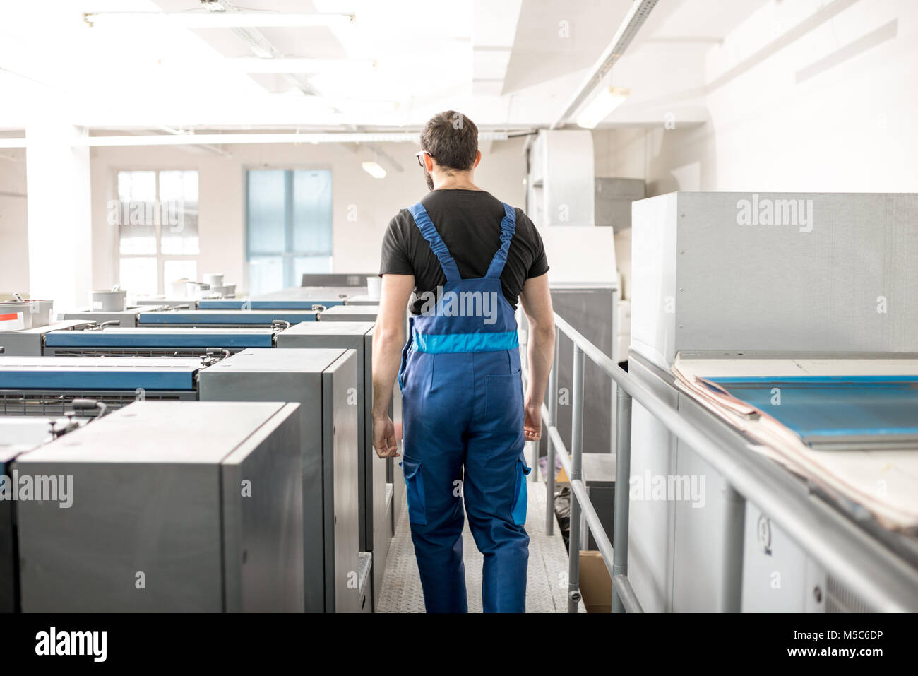 Supervising offset printing machine at the manufacturing Stock Photo ...