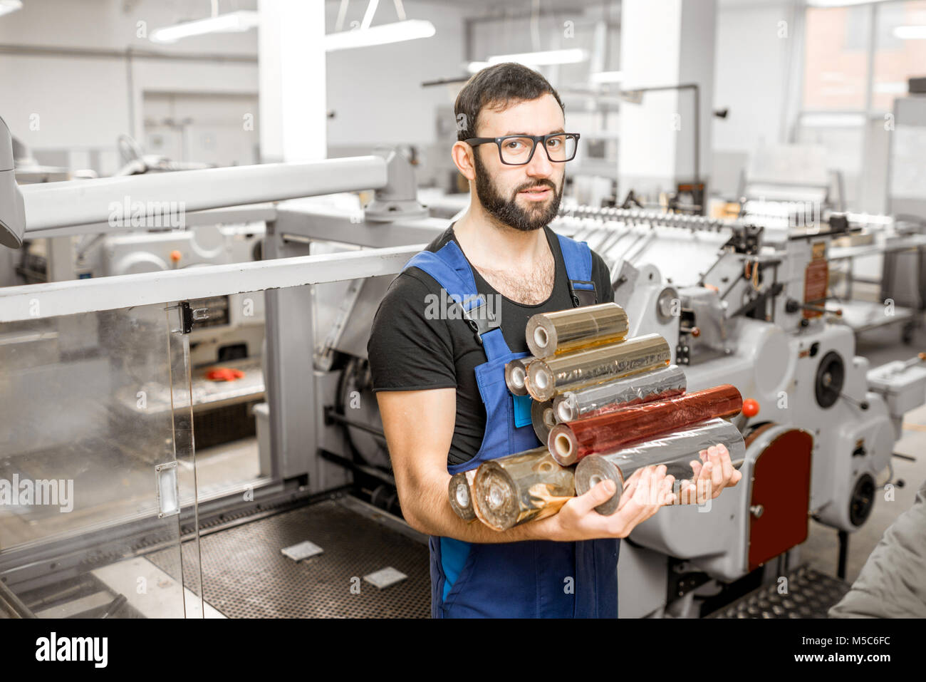 Worker with stamping foil rolls at the manufacturing Stock Photo - Alamy