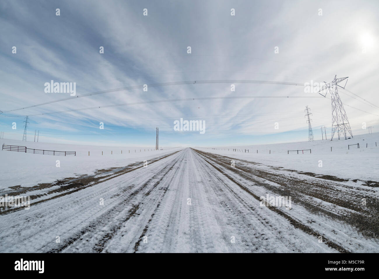 Alberta, Canada. Power transmission lines crossing a gravel road on the ...