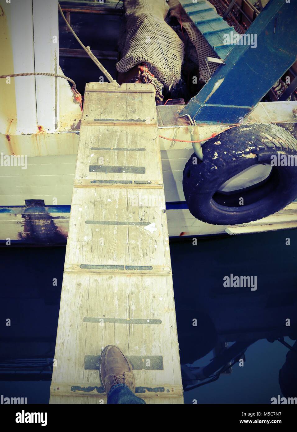 one foot of man over a footbridge to go on boat Stock Photo - Alamy