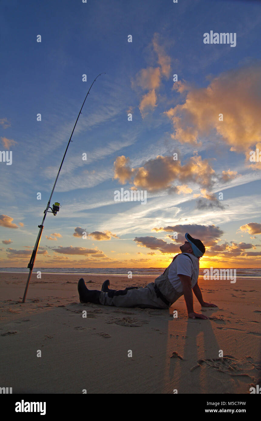 Man on beach with fishing pole hi-res stock photography and images - Alamy