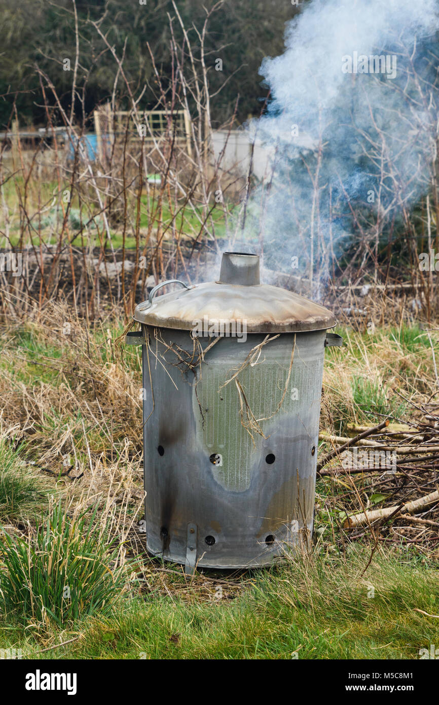 Galvanised steel Incinerator bin emitting smoke on an allotment Stock ...