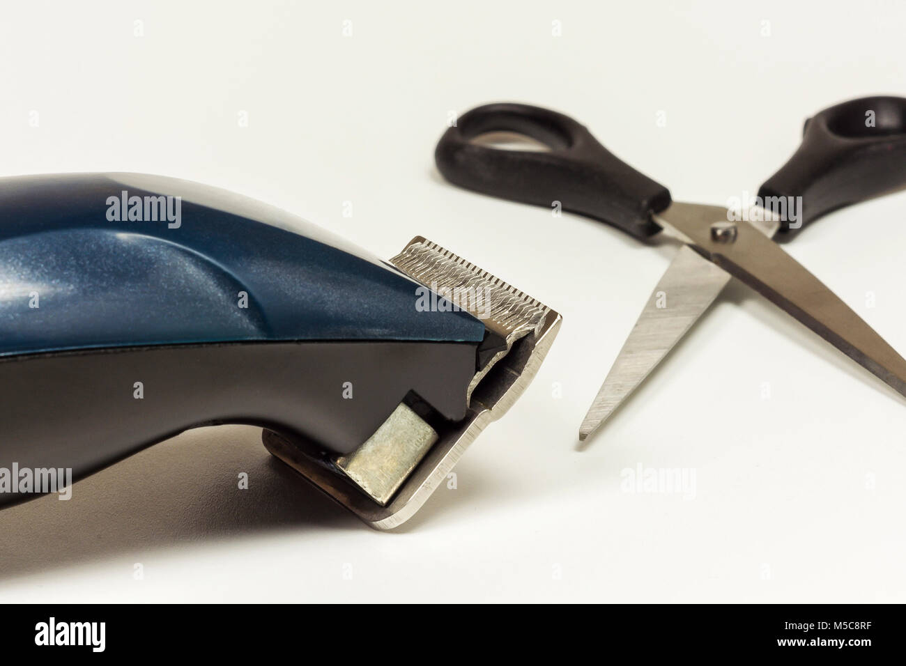 Hair clipper and scissors close up with blur elements on light ...