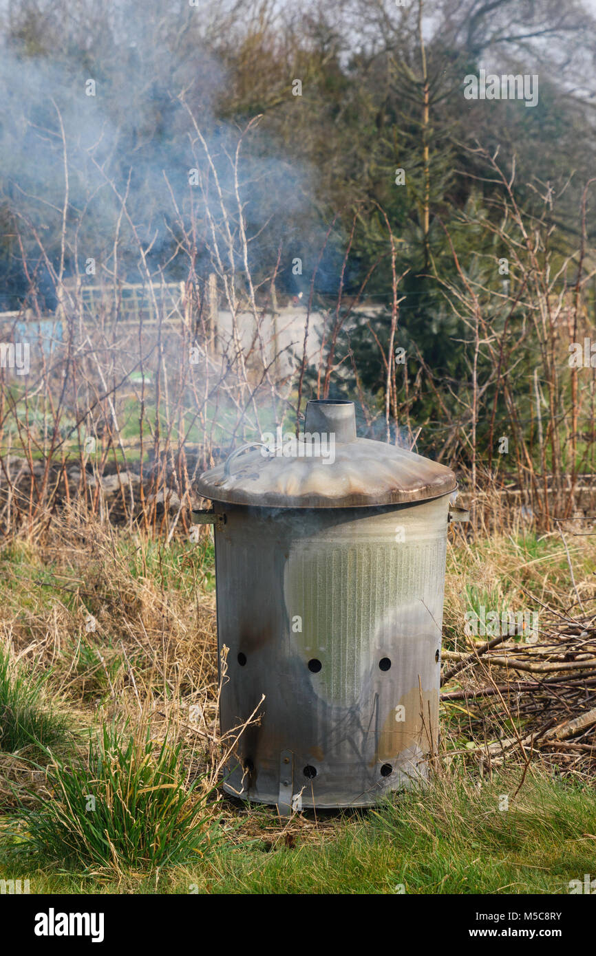 Galvanised steel Incinerator bin emitting smoke on an allotment Stock ...