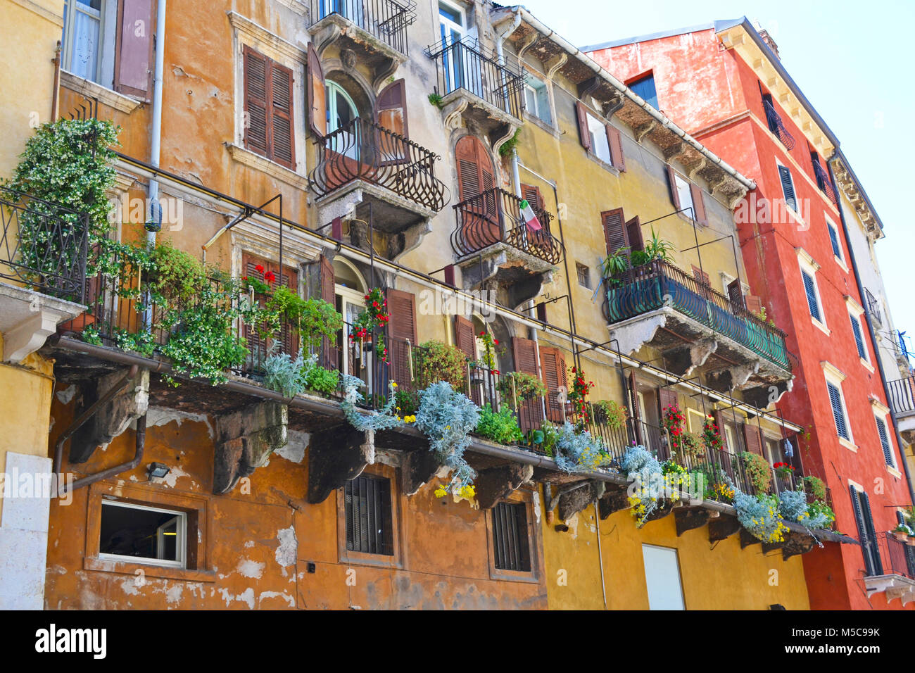 Beautiful traditional Italian building with flowers on balcony of ...