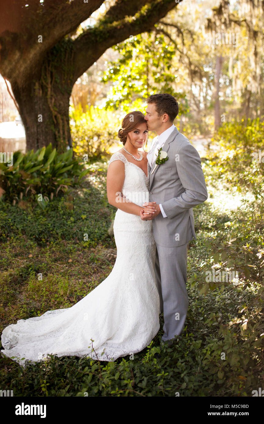 newly married couple having intimate moment in garden, full length ...