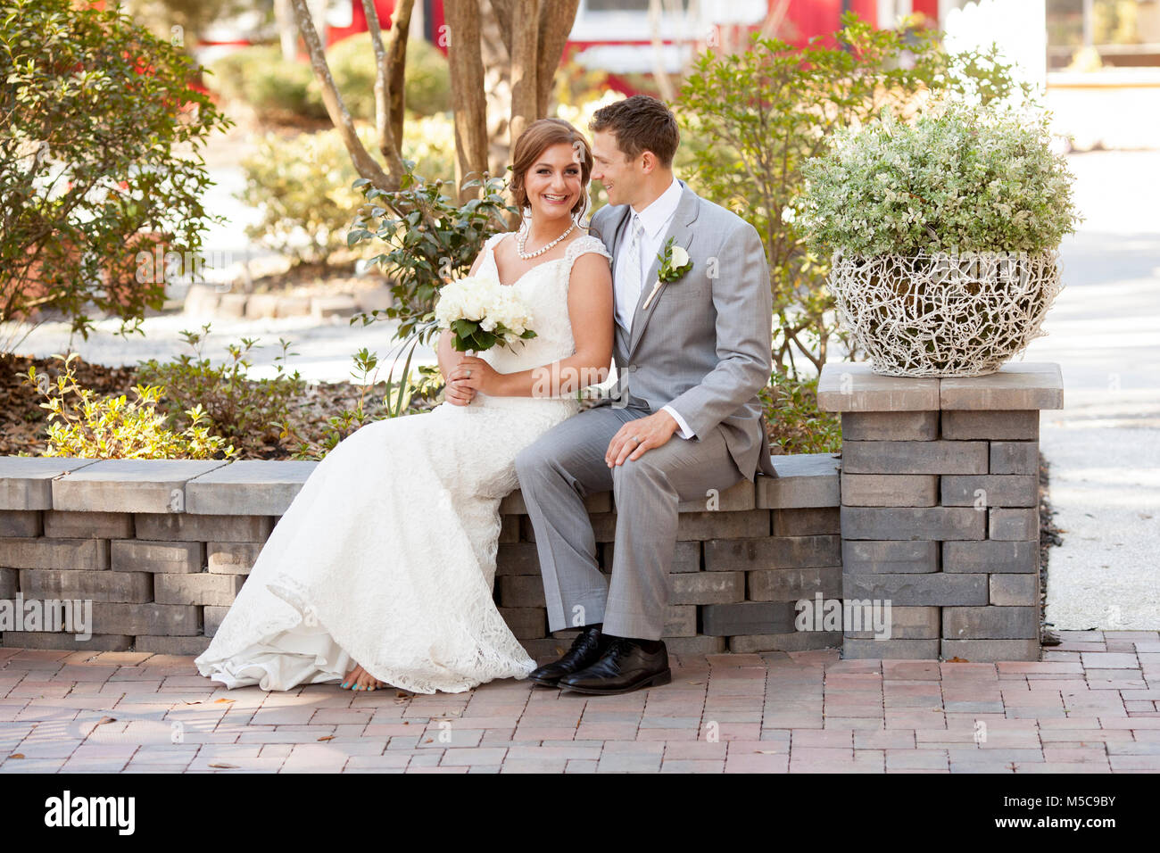 Bride and groom seated in the garden Stock Photo - Alamy