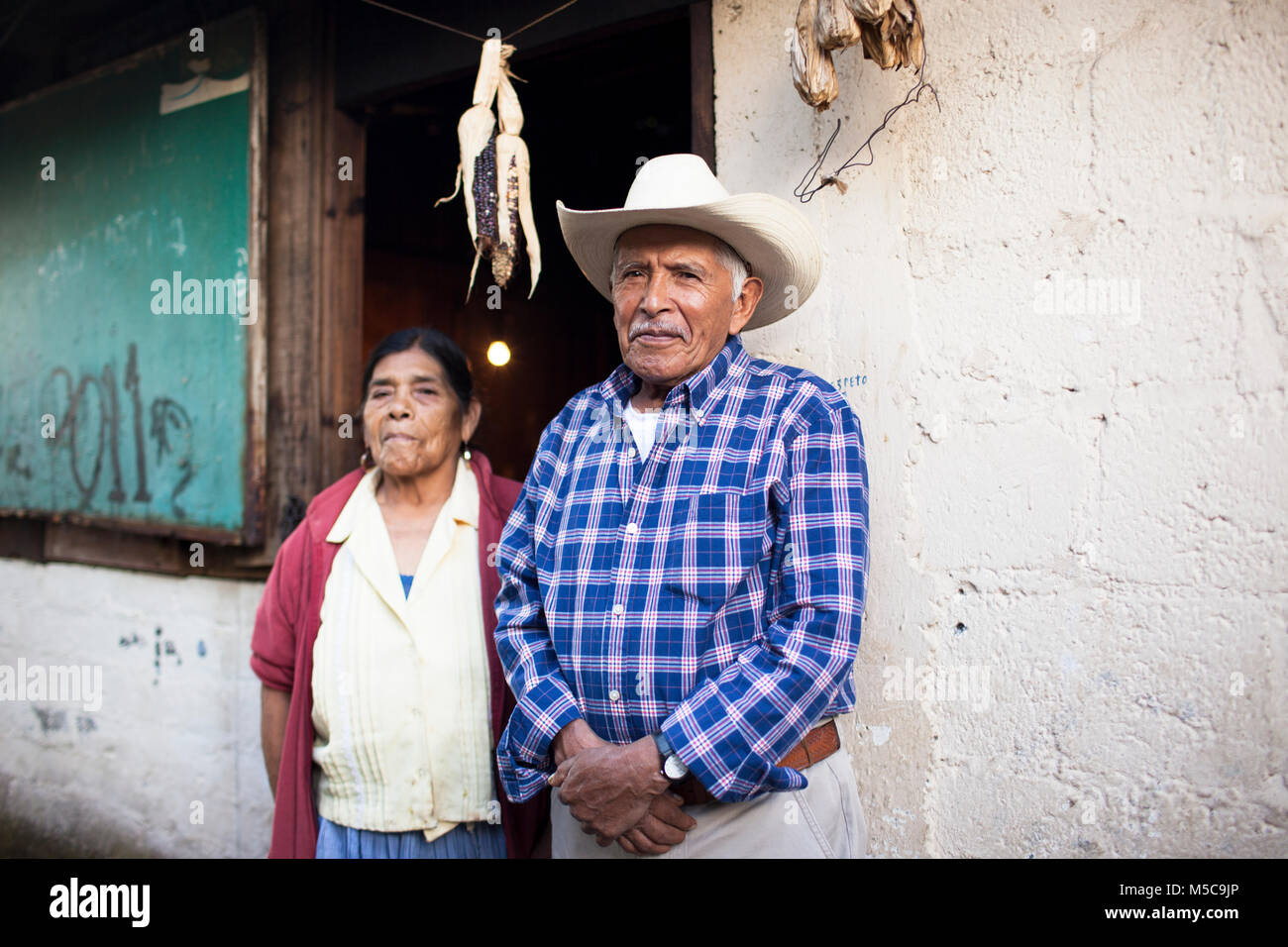 An elderly couple poses for a photo in front of their house during the ...