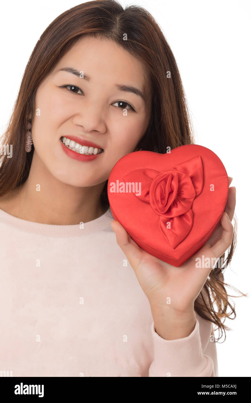 Asian woman enjoying a special gift of a box of chocolates in a red ...