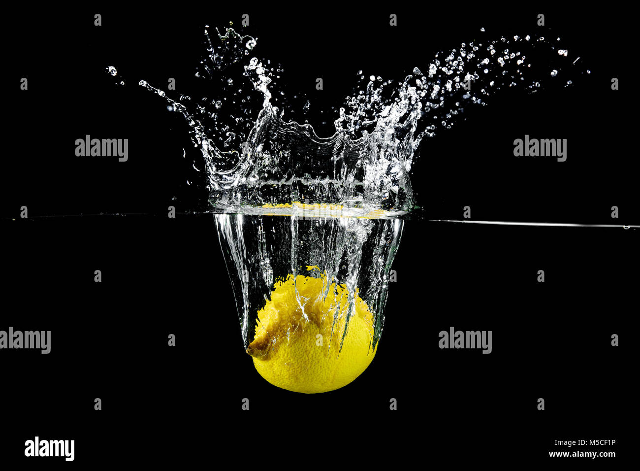 fresh yellow lemon in water splash on black background Stock Photo - Alamy