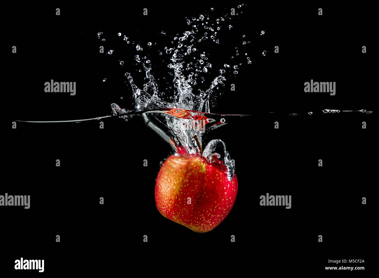 fresh red apple in water splash on black background Stock Photo - Alamy