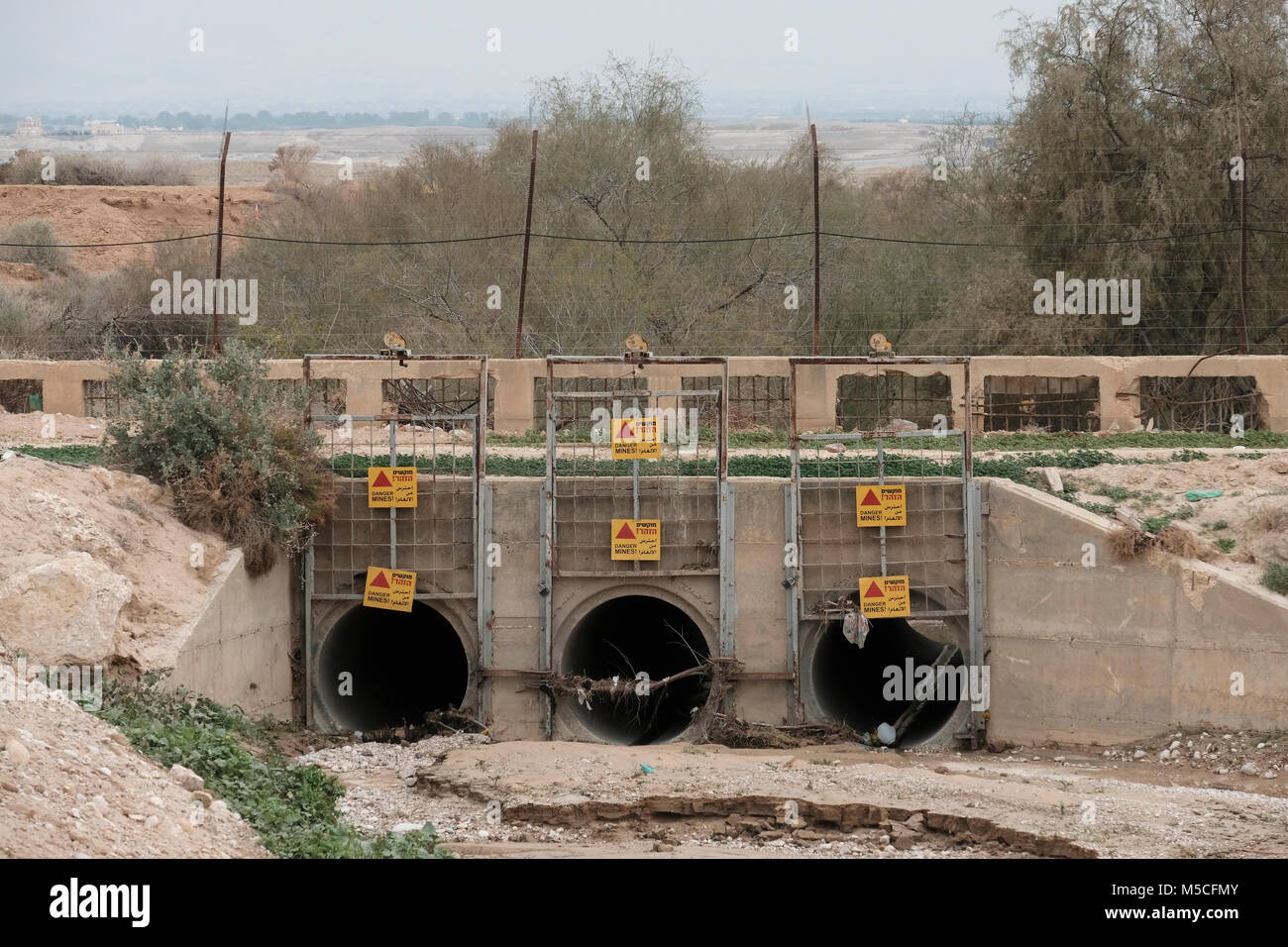 Warning landmine signs over sewer pipes at the border with Jordan near ...