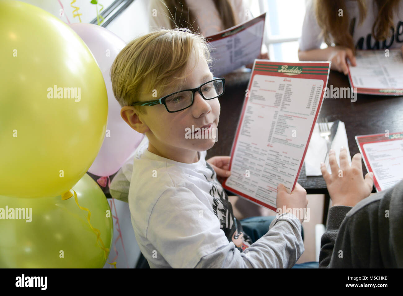 A child orders from a cafe menu at a birthday party Stock Photo - Alamy