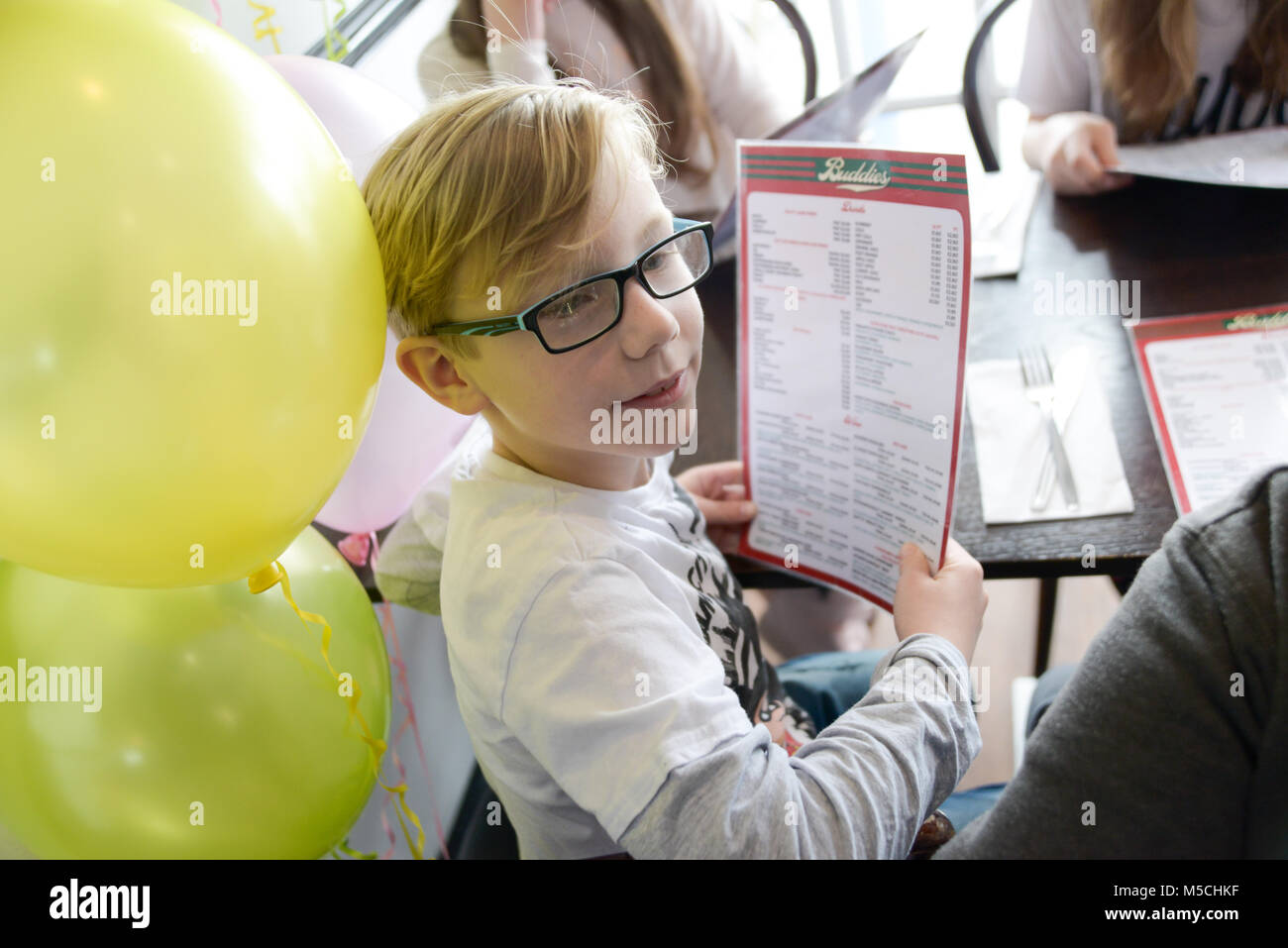 A child orders from a cafe menu at a birthday party Stock Photo - Alamy