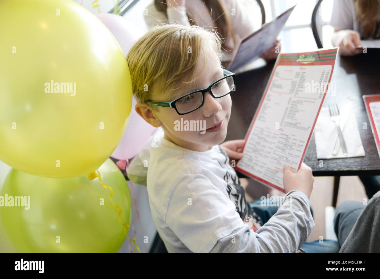 A child orders from a cafe menu at a birthday party Stock Photo - Alamy